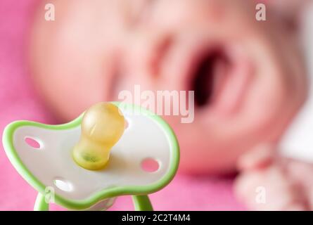 A young toddler crying with pacifier Stock Photo - Alamy