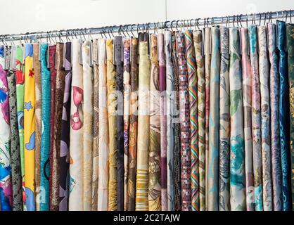 Different fabrics hang on the stand Stock Photo - Alamy