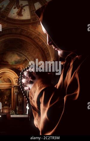 Medieval monk in robe praying holding silver cross in hand Stock Photo ...
