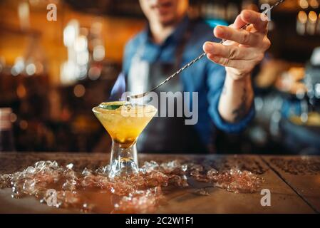 Male bartender prepares alcoholic coctail with ice. Barkeeper ...