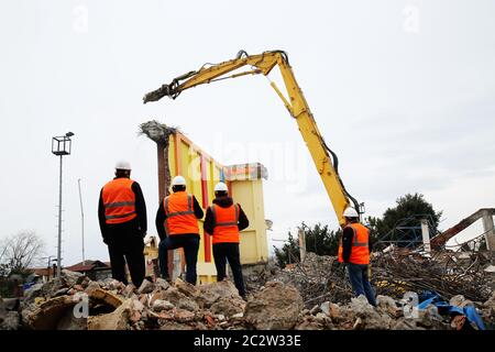 Engineer mans in helmet and jacket controlling outdoor construction ...