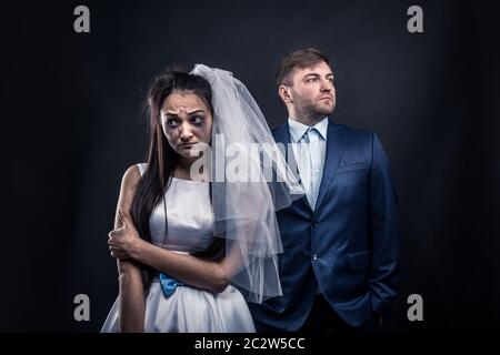 Disheveled bride with tear-stained face on black background. Studio ...