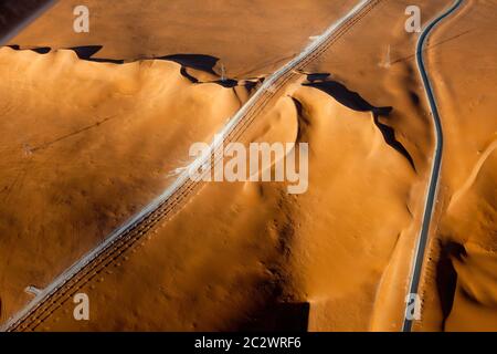 A road, oil export pipelines and electricity plyons in the Sahara ...