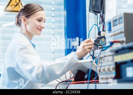 Engineer woman measuring electronic product on test bench Stock Photo ...