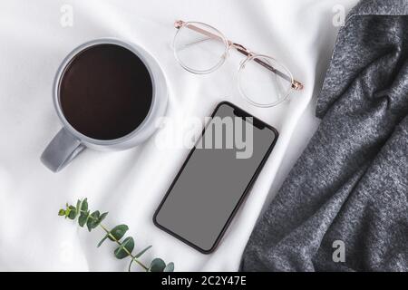Electronics layout in a white and gray bed flat lay Stock Photo - Alamy