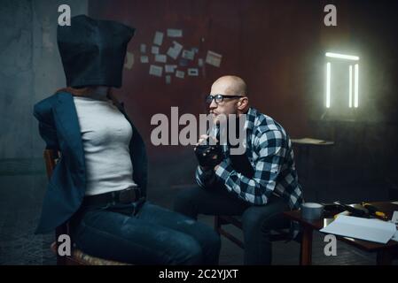 Female victim of maniac kidnapper with a bag on her head. Kidnapping is ...
