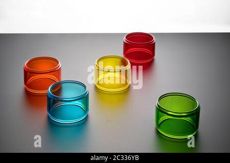 some colored containers on a black surface Stock Photo - Alamy