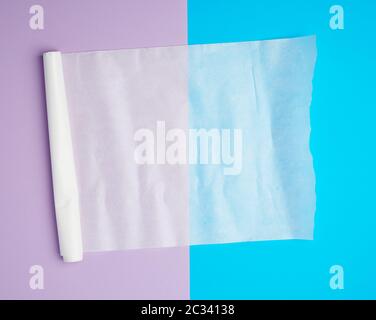 unwound white parchment baking paper on a blue purple background, top ...
