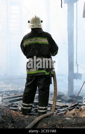 Firefighters work to extinguish a fire at a house after a Russian ...