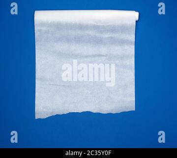 unwound white parchment baking paper on a blue purple background, top ...