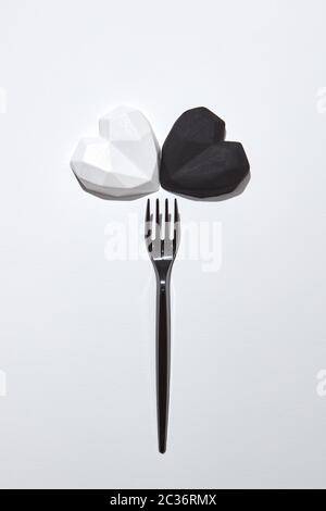 Black plaster fork with gypsum white heart Stock Photo - Alamy