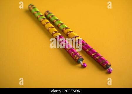 Dandiya sticks on a yellow background. Raas Garba or Dandiya Raas is ...