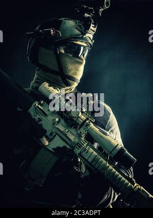 Elite forces soldier wearing mask, helmet and load carriage system ...