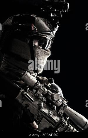 Elite soldier wearing face mask and night vision goggles, armed with ...