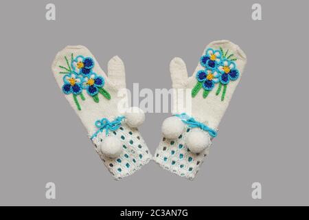 Mittens knitted from white yarn with decoration elements under violets ...