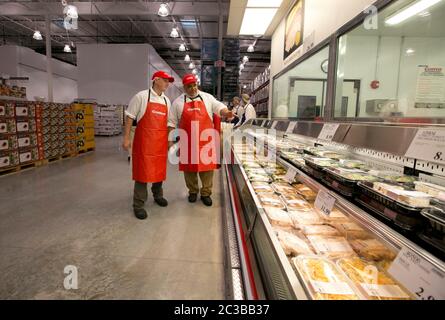 Costco warehouse employees in the fresh meat department discuss ...