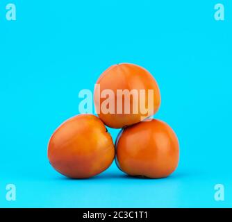 Three ripe persimmons on a blue background. Delicious fresh persimmon ...