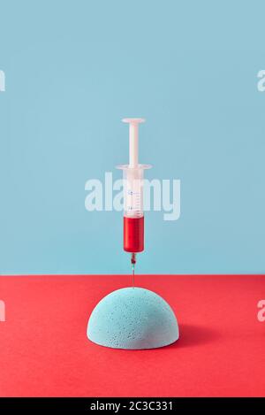 Injection of syringe with red liquid into styrofoam hemisphere Stock ...