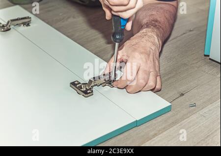master builds a furniture Cabinet. Mounting for furniture panels ...
