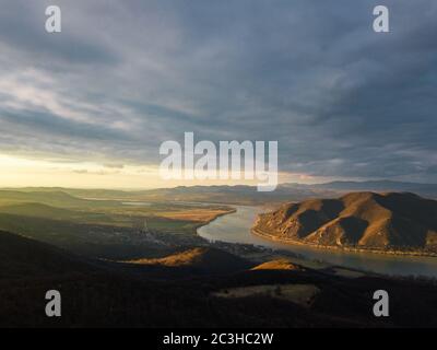 Mesmerizing scene of a river between forest and hill under the cloudy ...