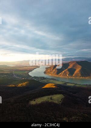 Mesmerizing scene of a river between forest and hill under the cloudy ...
