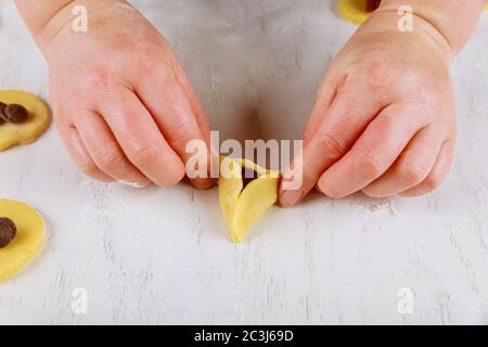 Woman making triangular cookie with jam for jewish holiday Purim Stock ...