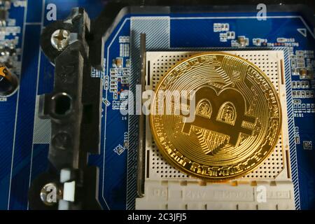 Gold shining bitcoins on a motherboard Stock Photo - Alamy