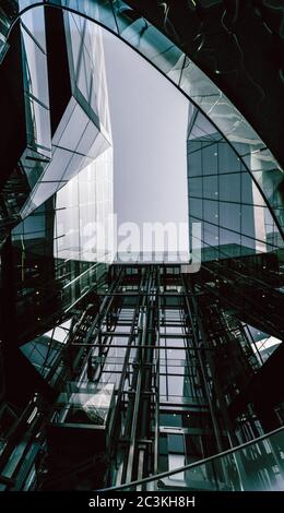 Vertical low angle shot of a geometrical buildings under the clear blue ...