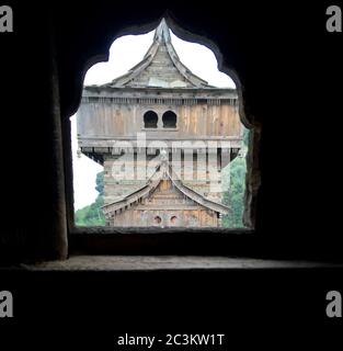 View from a dark stone window reveals a distant ancient fortress ...