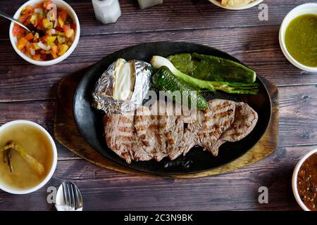 High angel closeup shot of fine cuts of meat on a black plate Stock ...