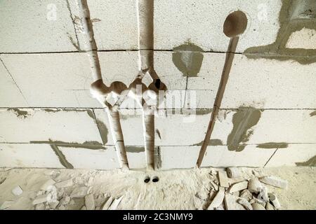 Deep grooves and holes in white brick wall made for installation of ...