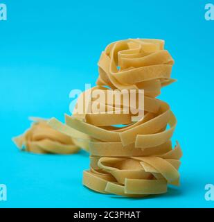 Raw pasta fettuccine on blue background food and drink concept Stock ...