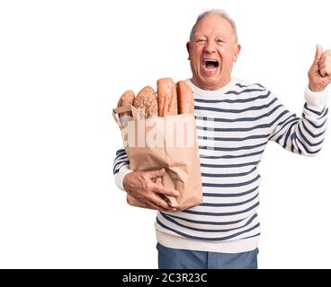proud old man with bag holding fist up and cheering the winning in ...