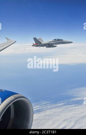 A view from inside passenger jetliner cabin of a military jet fighter ...