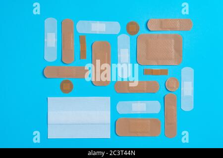 some plasters of various shapes on a blue surface Stock Photo - Alamy