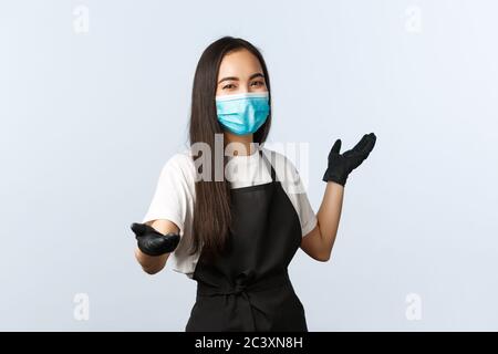 Portrait of asian smiling barista, girl serving coffee, standing near ...