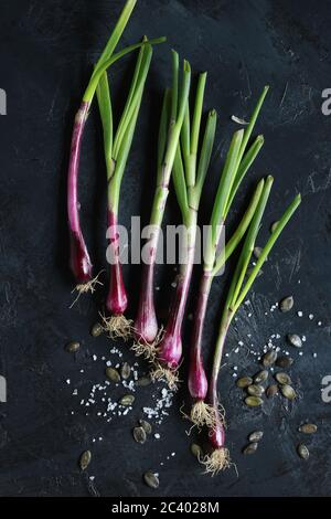 purple spring onions on dark table background Stock Photo - Alamy