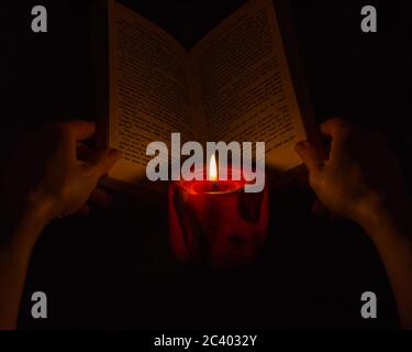 Reading a book by candlelight Stock Photo - Alamy