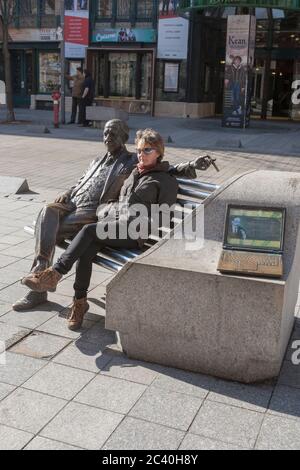Tourist poses with the statue of Imre Kálmán by Gábor Veres outside the ...
