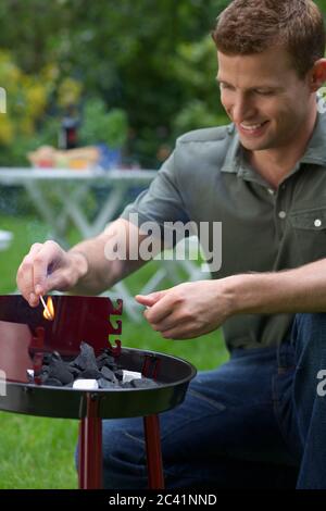 Young man lights fire Stock Photo - Alamy