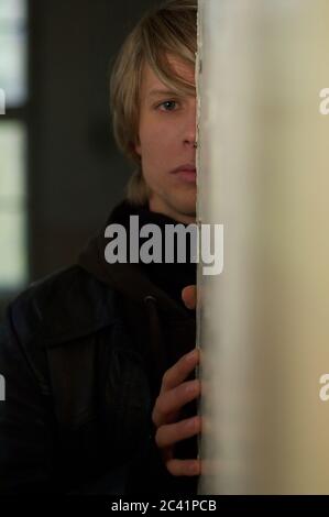 Man looking around corner at camera Stock Photo - Alamy
