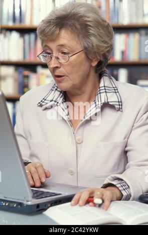 Old lady typing on laptop, looking for goods and shopping, modern ...