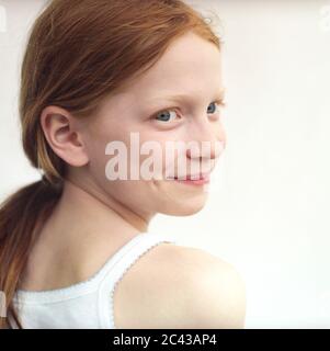 Girl with red hair smiles cheekily - physicality Stock Photo - Alamy