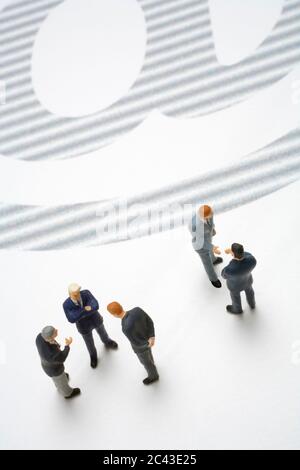 Businessman figures stand on an @ sign Stock Photo - Alamy
