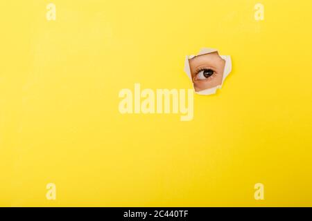 Eye peeking through torn paper Stock Photo - Alamy