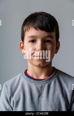 Close-up portrait of cute boy biting lip at home Stock Photo - Alamy