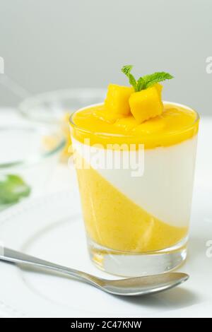 Italian dessert panna cotta with mango in glass on white background ...