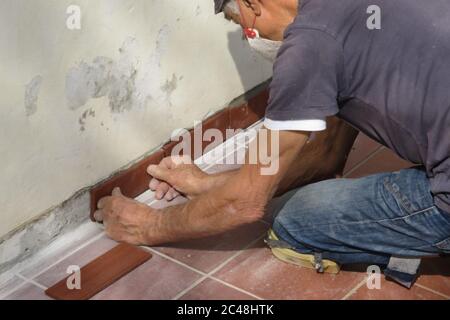 High angle shot of a tiler laying ceramic tiles Stock Photo - Alamy