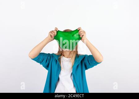 Funny girl holding green slime looks like gunk in front of her face ...