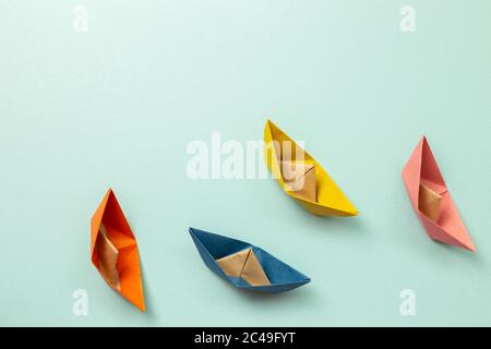 The colorful paper ships on the world map placed on a wooden table ...
